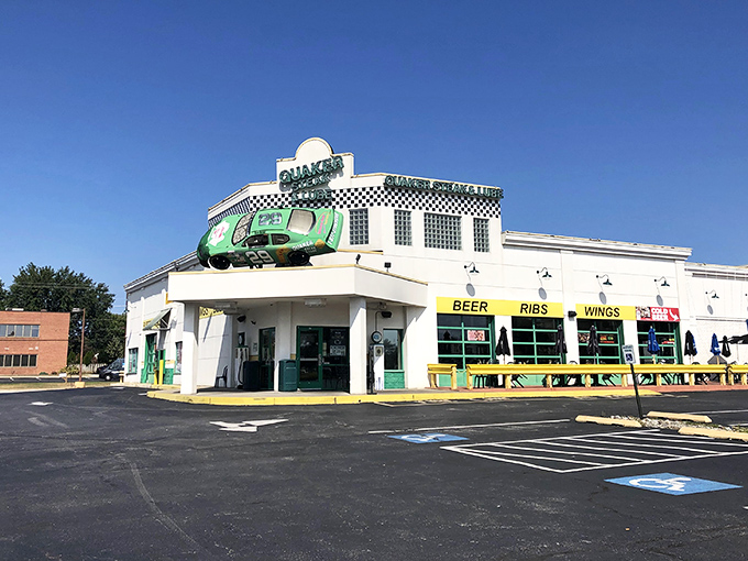 The green race car perched atop this white building isn't just decoration—it's a promise of the high-octane flavor experience waiting inside.