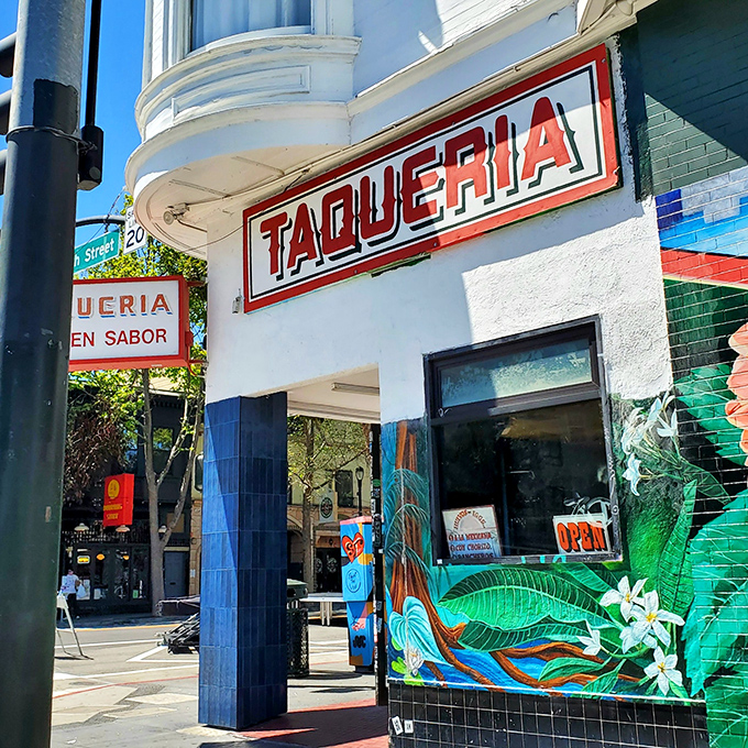 The iconic red "TAQUERIA" sign beckons hungry souls like a lighthouse for flavor-seekers at the corner of 18th Street in San Francisco's Mission District.