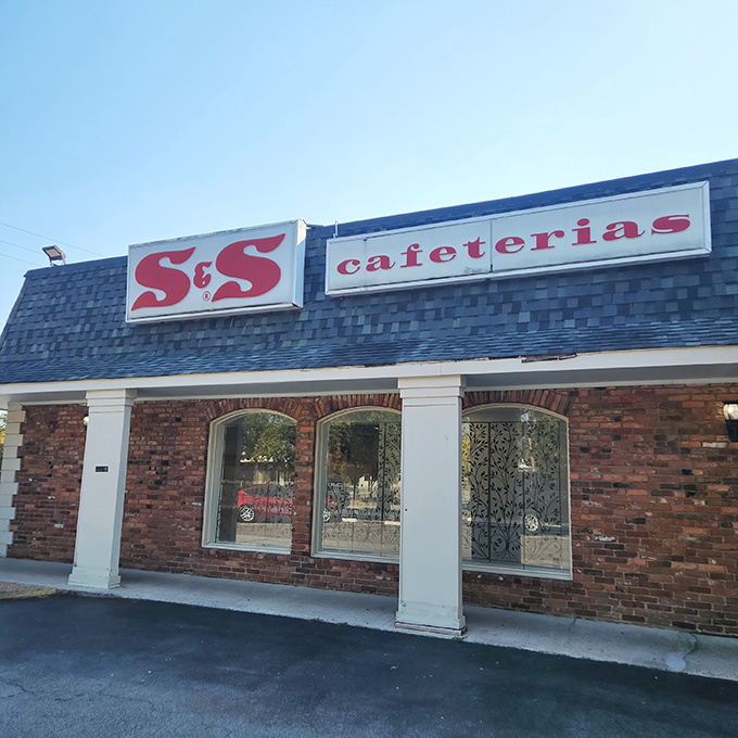 The iconic red S & S Cafeteria sign stands as a beacon of hope for hungry souls seeking authentic Southern comfort food without pretension.