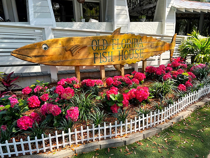 The iconic fish-shaped sign welcomes you like an old friend. Lush tropical plants frame this wooden masterpiece, promising seafood adventures ahead.