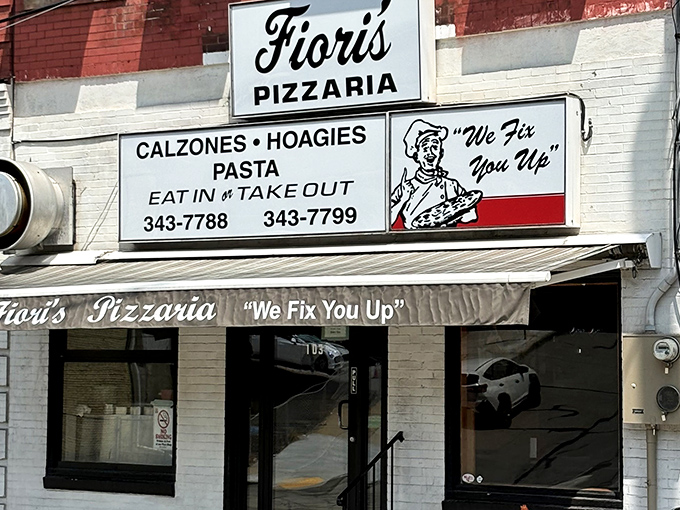 The classic storefront of Fiori's Pizzaria promises culinary salvation with its charming "We Fix You Up" slogan &ndash; Pittsburgh's version of pizza therapy.
