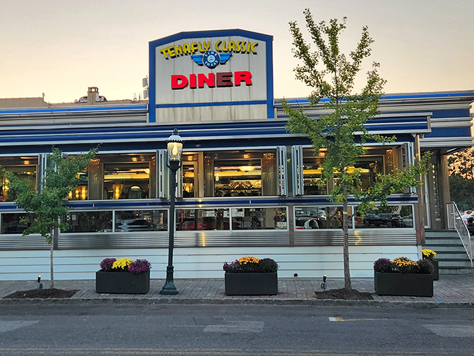 The classic blue-and-chrome exterior of Tenafly Classic Diner glows at dusk, a beacon of comfort food promising that yes, everything is going to be delicious.