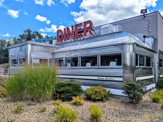 Like a chrome time machine parked in Rindge, Hometown Diner's gleaming exterior promises authentic comfort beneath that iconic red sign.