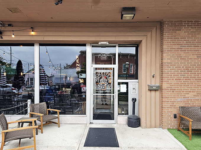 The welcoming entrance to Homestead Taproom & Kitchen promises culinary adventures behind those glass doors, with cozy patio seating ready for Ohio's perfect days.