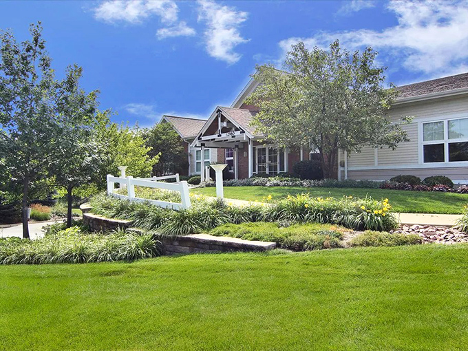 Welcome home! This charming entrance to a Sun City Huntley residence showcases the meticulous landscaping that makes every day feel like you're living in a resort brochure.