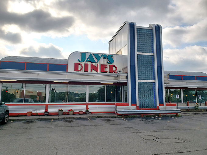 The iconic blue and red exterior of Jay's Diner stands like a time capsule against Rochester's skyline, beckoning hungry travelers with its retro charm.