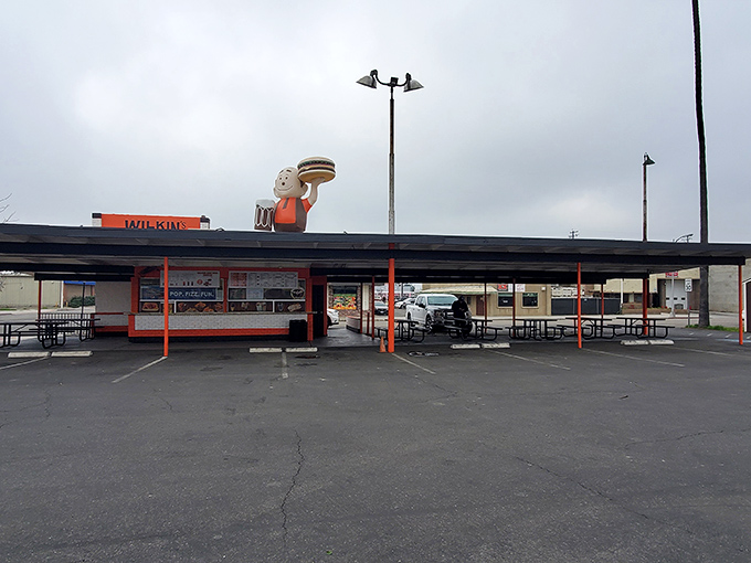 The iconic burger boy statue stands proudly atop Wilkin's Drive-In, waving hello with a giant burger that promises delicious things to come.