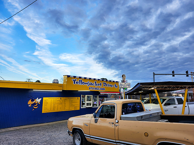 The Yellow Jacket's sunny yellow and blue exterior isn't just a building—it's a time machine to when drive-ins ruled American dining culture.