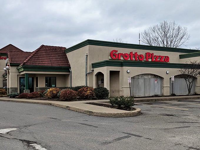The iconic red Grotto Pizza sign welcomes hungry travelers like a culinary lighthouse. Those distinctive terra cotta roof tiles have sheltered countless pizza pilgrimages.