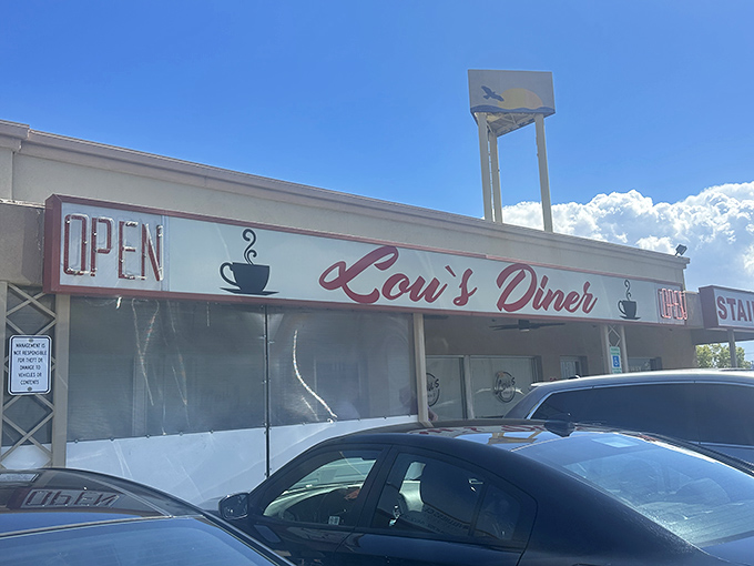 Lou's Diner announces itself with no-nonsense simplicity – just a coffee cup icon and that classic "OPEN" sign promising comfort food salvation under the Nevada sun.