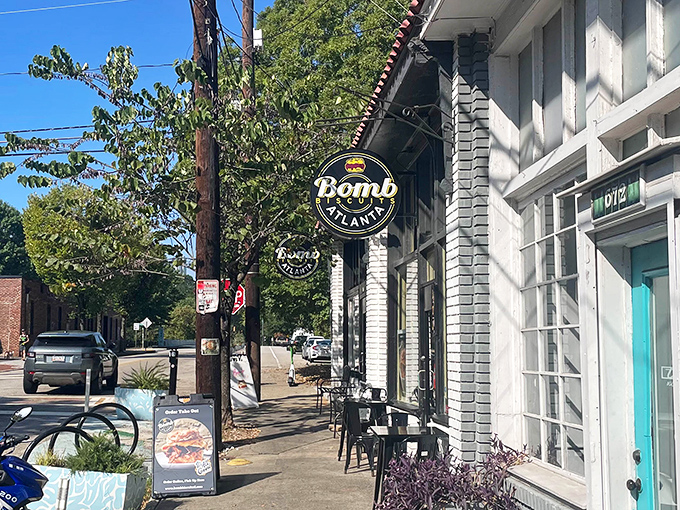 The iconic black and gold Bomb Biscuits sign beckons from the white brick storefront, promising carb-laden treasures that'll make your morning infinitely better.