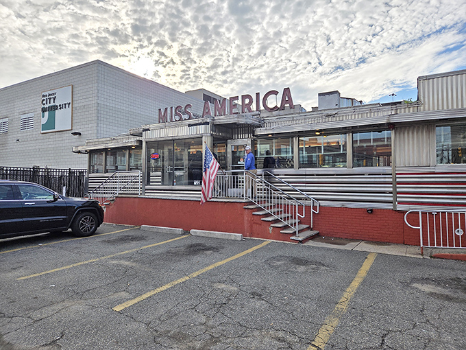 The classic stainless steel exterior of Miss America Diner gleams under Jersey City skies, a time capsule of American dining culture waiting to welcome hungry visitors.