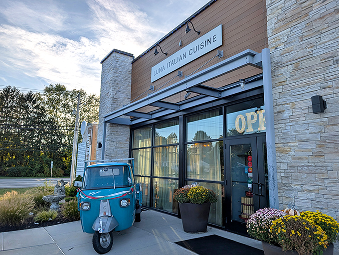 Luna's charming exterior welcomes you with that adorable blue Piaggio Ape – Italy's answer to "how small can we possibly make a delivery truck?"