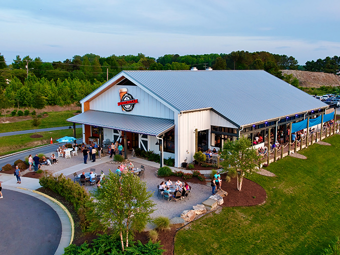 Sunset magic at Shorebreak Pizza & Taphouse, where the Pungo countryside meets coastal cuisine. The white farmhouse exterior promises comfort before you even step inside.