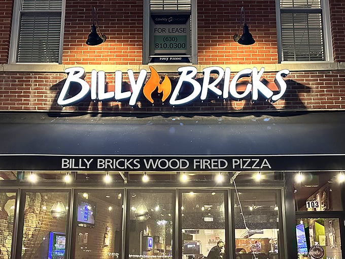 At night, the illuminated Billy Bricks sign serves as a beacon for pizza pilgrims wandering through Wheaton's streets in search of wood-fired perfection.