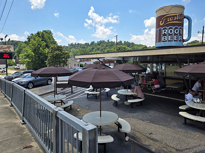 The iconic giant root beer mug stands sentinel over Frostop Drive-In, beckoning hungry travelers like a lighthouse for comfort food enthusiasts.