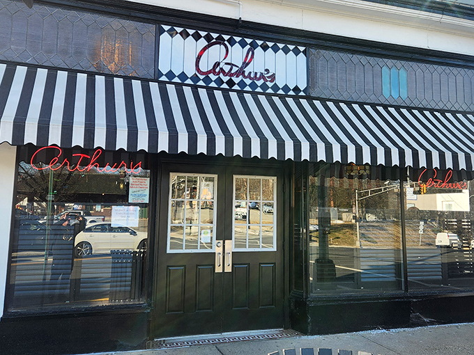 The classic black and white awning of Arthur's Tavern stands as a beacon for steak lovers, promising old-school delights within those unassuming doors.