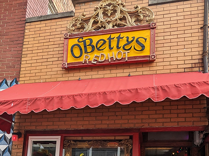 The ornate vintage sign for O'Betty's Red Hot glows like a beacon of hope for hungry travelers. That red awning practically whispers, "Come in, we've got what you need."