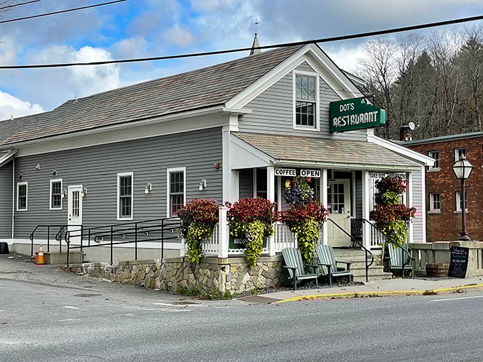 The iconic green sign beckons like an old friend, while hanging flower baskets create a Vermont welcome that's prettier than a postcard.