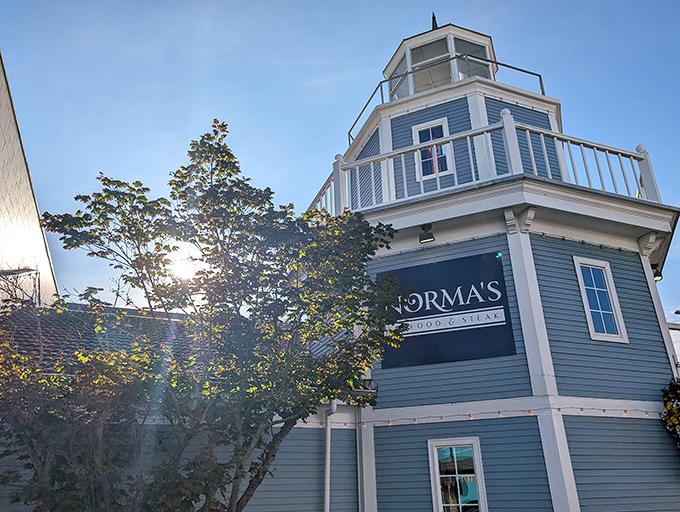 Sunlight dances through the trees, illuminating Norma's iconic lighthouse tower – a blue-hued siren call to hungry travelers along the coast.