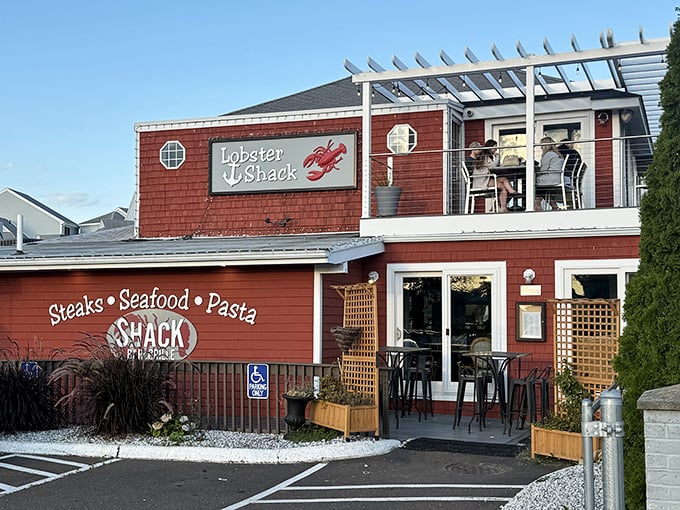 The iconic red-shingled exterior of The Lobster Shack stands like a beacon of seafood salvation on the East Haven shoreline. Those porthole windows aren't just for show! 