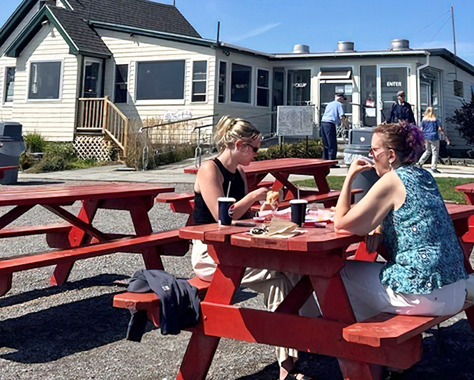 Diners enjoying the simple pleasure of fresh seafood at red picnic tables &ndash; the Maine equivalent of five-star dining.