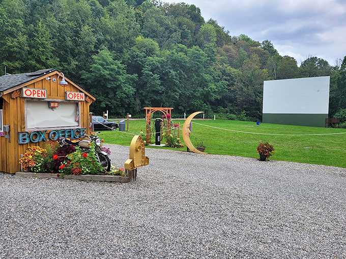 The classic movie screen stands tall against the Hudson Valley greenery, creating nature's perfect theater backdrop. Cars line up for the evening's entertainment.