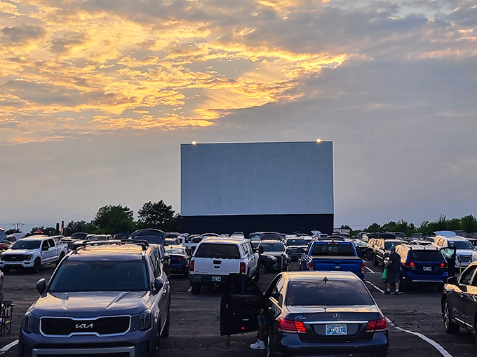 The golden Oklahoma sunset creates nature's perfect backdrop for movie night, as cars gather beneath the Winchester's iconic screen.
