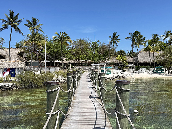 The wooden walkway to paradise beckons across crystal-clear waters, promising Florida Keys magic with every step toward Marker 88's thatched-roof oasis.