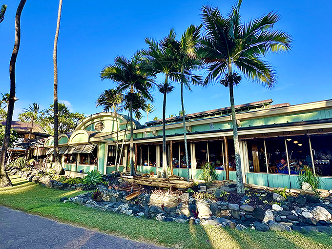 Paradise found! Mama's Fish House's aquamarine exterior peeks through swaying palms like a tropical mirage that promises culinary adventures beyond the ordinary.