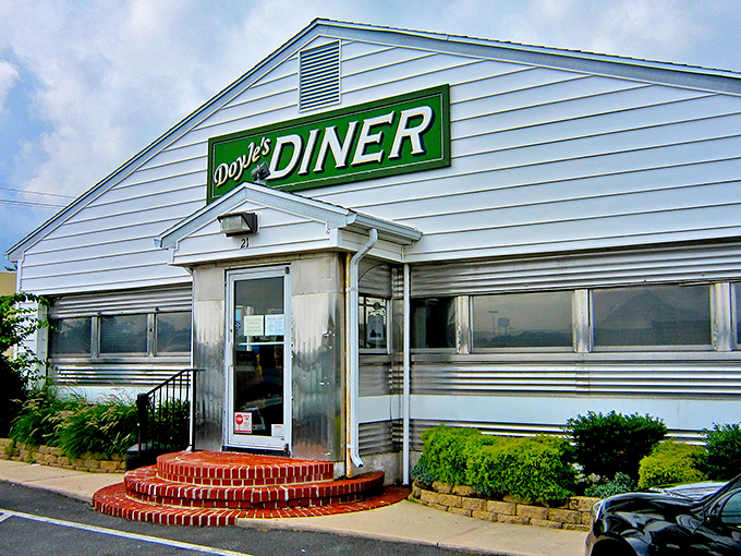 The iconic green sign of Doyle's Diner beckons hungry travelers like a lighthouse for the famished. Classic Americana at its finest.