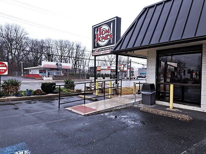 The iconic Tom Jones sign glows against an overcast sky, promising comfort food treasures that locals have cherished for generations.