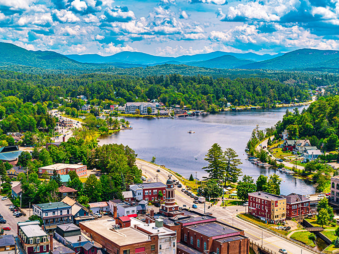 Behold the Adirondack dreamscape! Saranac Lake unfolds like nature's perfect postcard, where mountains meet water in a display that makes Instagram filters redundant.