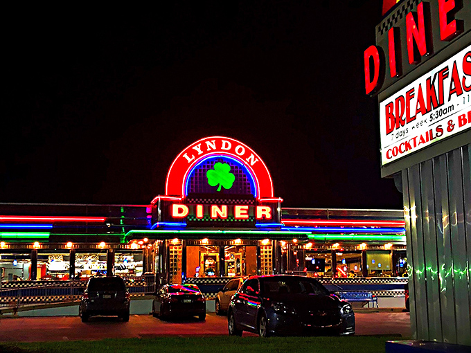 The neon shamrock glows like a beacon in the night, promising comfort food salvation to weary travelers and locals alike.