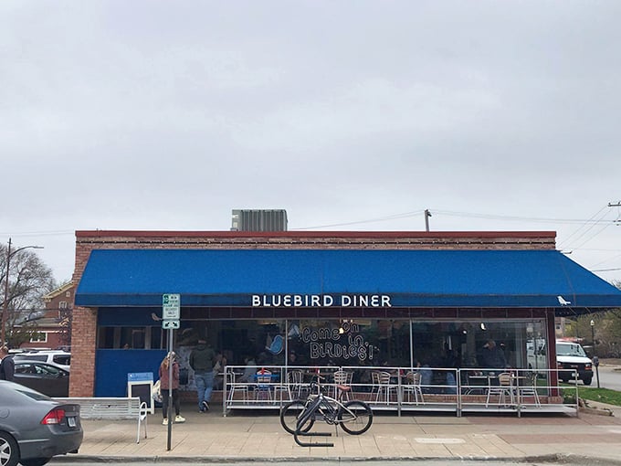 The iconic blue awning of Bluebird Diner stands out like a superhero cape against Iowa City's skyline, promising breakfast adventures within.