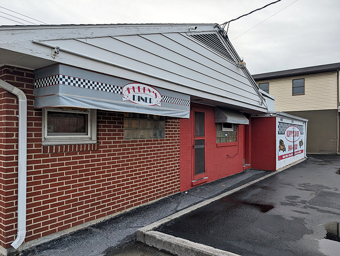 The brick-and-red exterior of Kuppy's Diner stands like a time capsule of Americana, complete with classic checkered trim that practically whispers "good food inside."