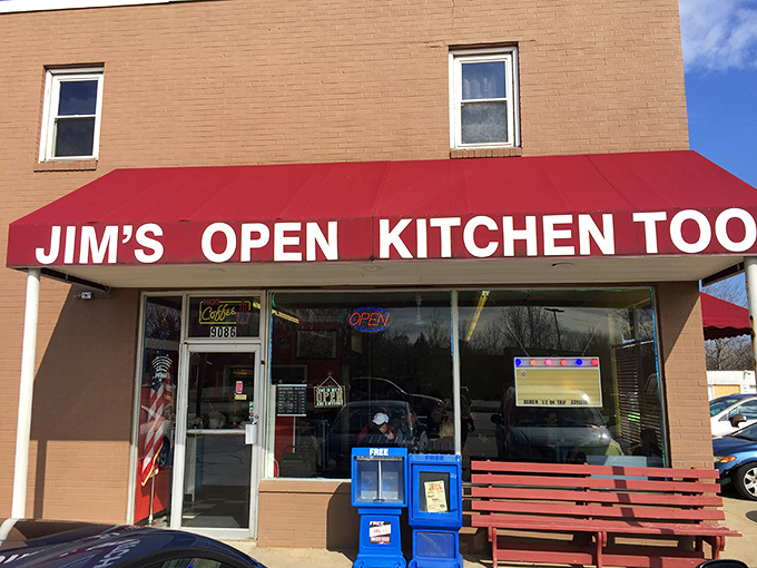 The iconic red awning of Jim's Open Kitchen Too stands out against the beige building like a beacon for breakfast enthusiasts everywhere.
