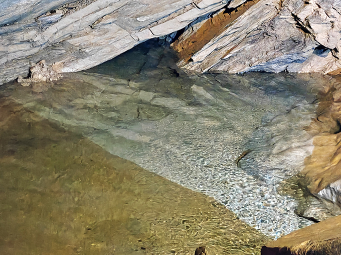 The crystal-clear waters of the mysterious Lost River reflect the cavern walls, creating a mirror effect that doubles the underground magic.