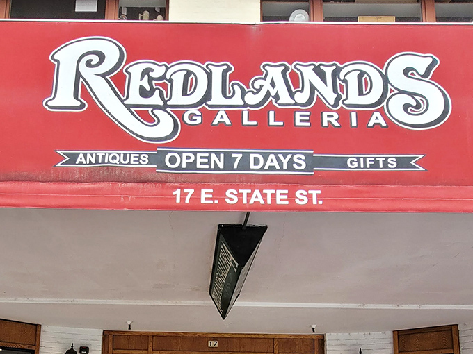 The welcoming facade of Redlands Galleria beckons treasure hunters with its vintage cart display and warm wooden entrance. Time travel begins here!