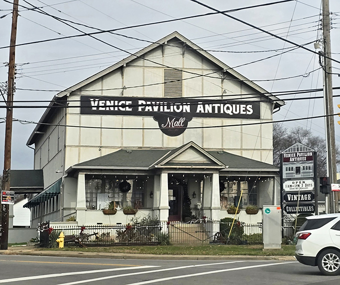The white facade of Venice Pavilion Antiques welcomes treasure hunters with its charming porch and vintage signage, promising adventures in nostalgia just beyond those doors.
