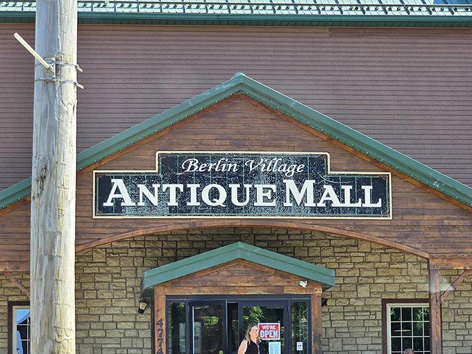 The iconic red barn exterior of Berlin Village Antique Mall stands as a beacon for treasure hunters, complete with that charming Downtown Diner sign promising sustenance after antiquing adventures.