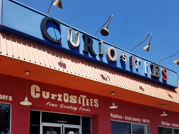 The vibrant storefront of Curiosities beckons treasure hunters with its bold signage and promise of "Fine Quality Finds" under the Dallas sun.