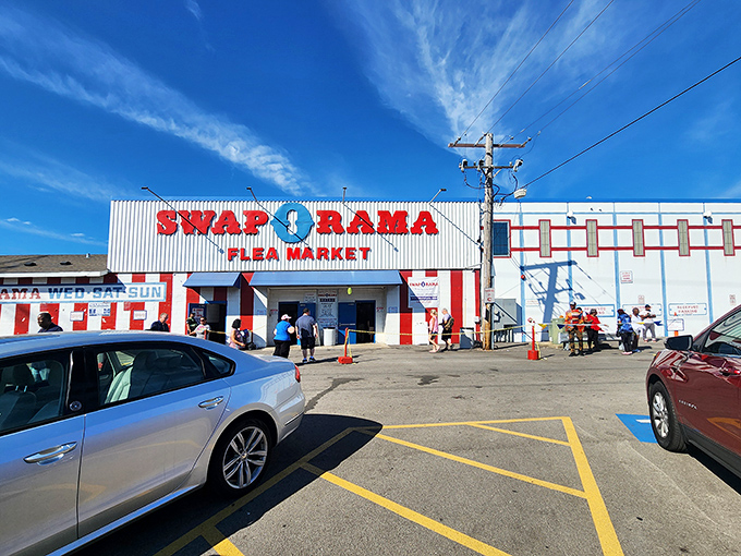 The iconic red and white striped entrance to Swap-O-Rama stands like a carnival barker promising treasures within. Step right up to bargain paradise!