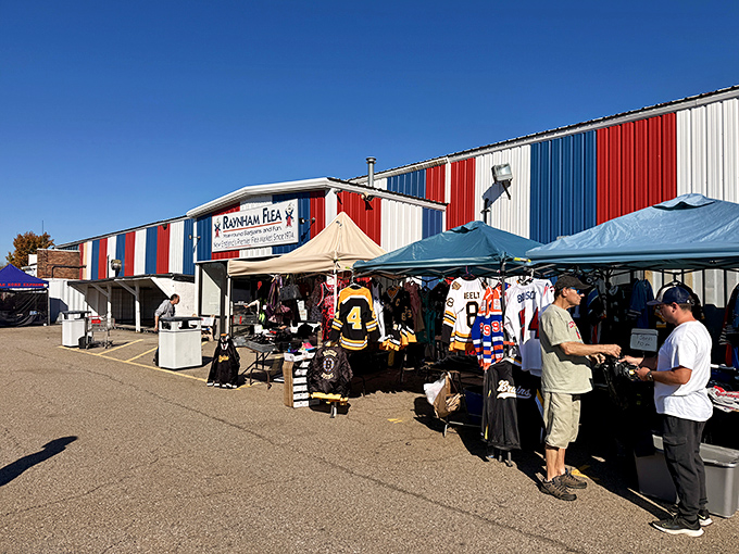 The red, white, and blue exterior of Raynham Flea Market stands like a patriotic beacon for treasure hunters. Where bargain-seeking becomes an Olympic sport.