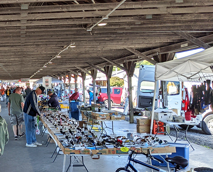 Under the weathered wooden beams, treasure hunters scan tables laden with tools, gadgets, and mysteries waiting to be discovered.