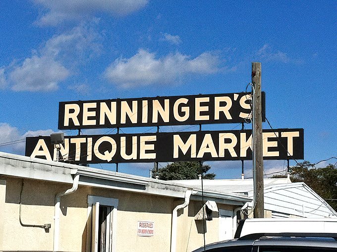 The iconic Renninger's sign stands tall against a blue Pennsylvania sky, beckoning treasure hunters like a siren call to antiquing paradise.