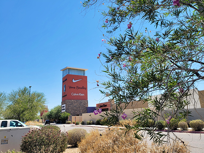 The towers of retail temptation rise above the desert landscape, beckoning bargain hunters like modern-day sirens.