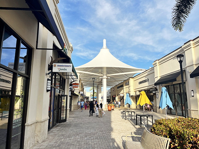 The shopping boulevard of dreams, where those elegant white canopies provide merciful shade for your retail marathon. Florida sunshine meets discount paradise.