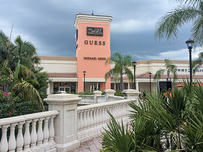 The iconic pink tower stands like a fashionable lighthouse, guiding bargain hunters to shores of savings amid Florida's swaying palms.