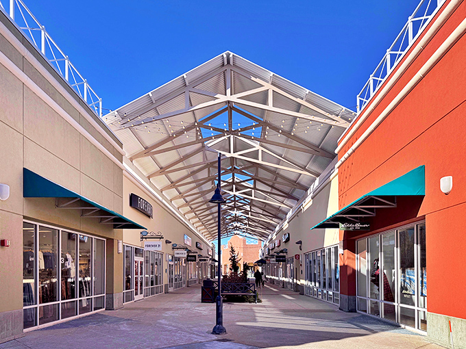 Bright blue skies frame the covered walkways where shopping dreams come true. The architecture says "upscale" but the prices whisper "affordable luxury."